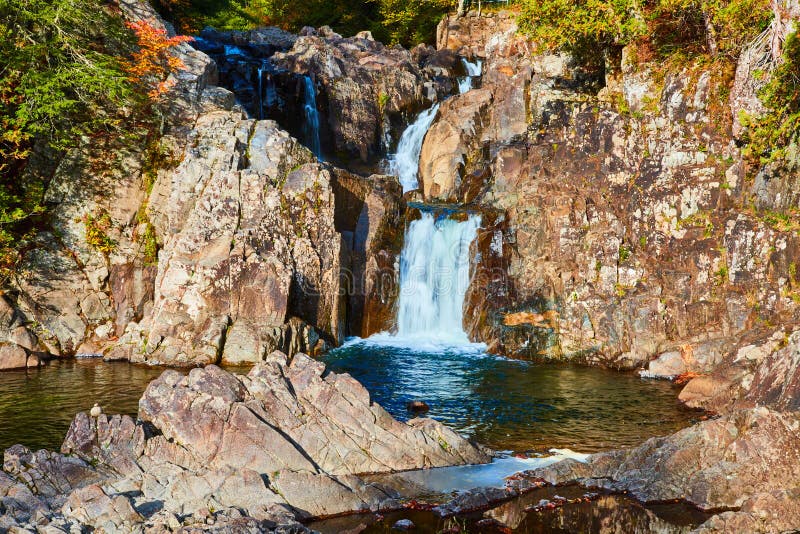Looking Up at Waterfalls Pouring through Rocks in Forest Stock Photo ...