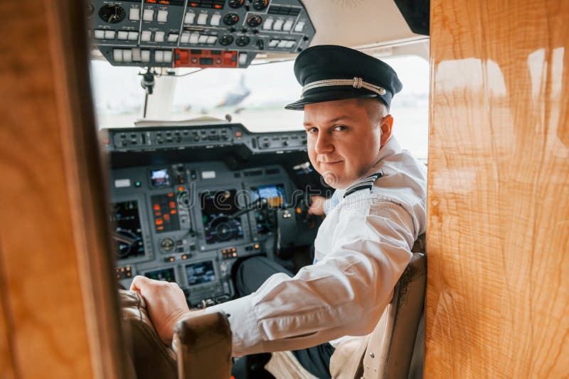Looks Behind. Pilot on the Work in the Passenger Airplane Stock Photo ...