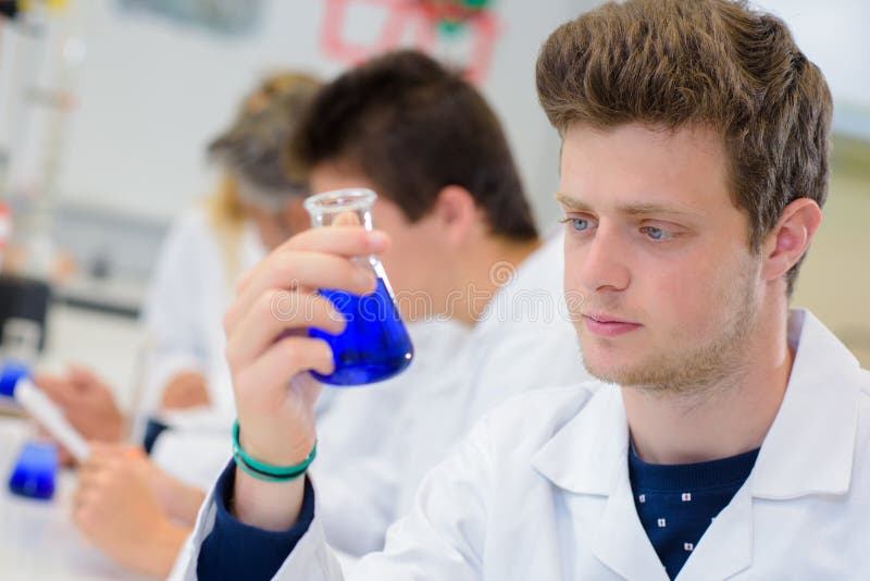He Looks at Chemical Inside Flask Stock Photo - Image of flask ...