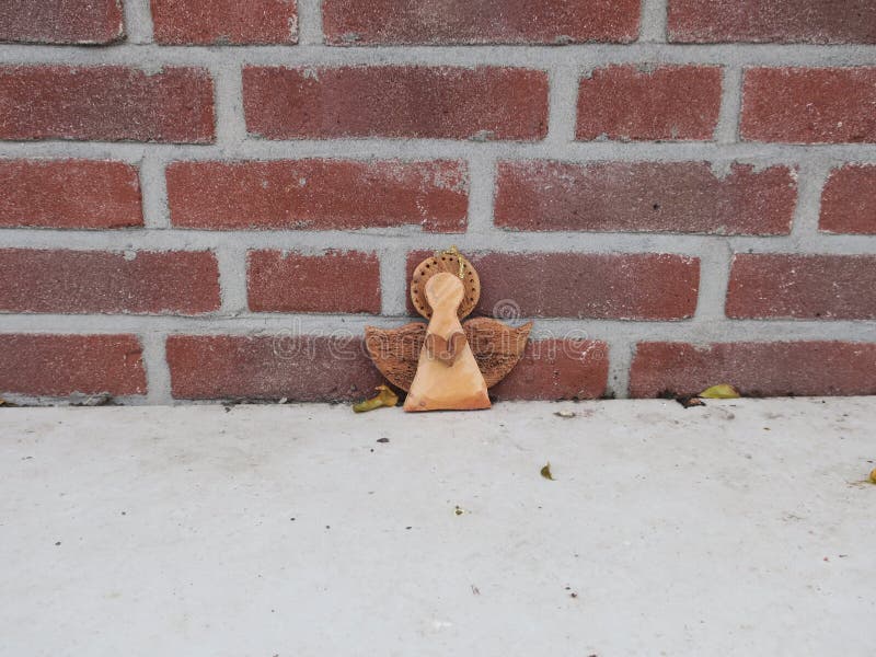 Lost Wooden Angels Leaning Against a Red Brick Wall Stock Image - Image ...