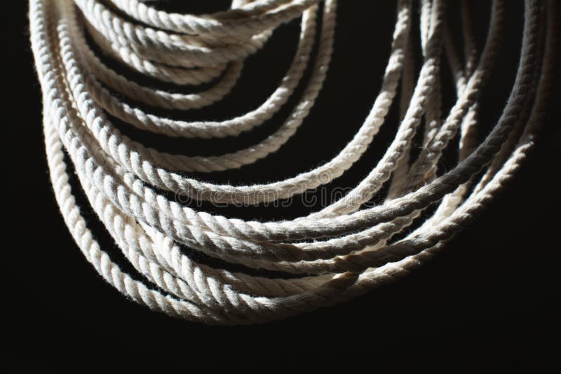 A Lot of Dangling White Cotton Ropes on Black Background Stock Photo ...