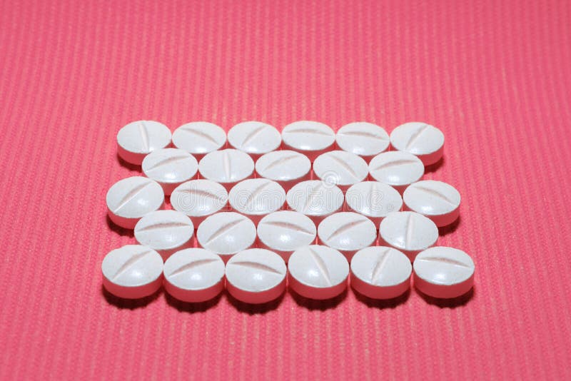 A Lot of White Smooth Convex Tablets with a Dividing Strip on a Pink ...