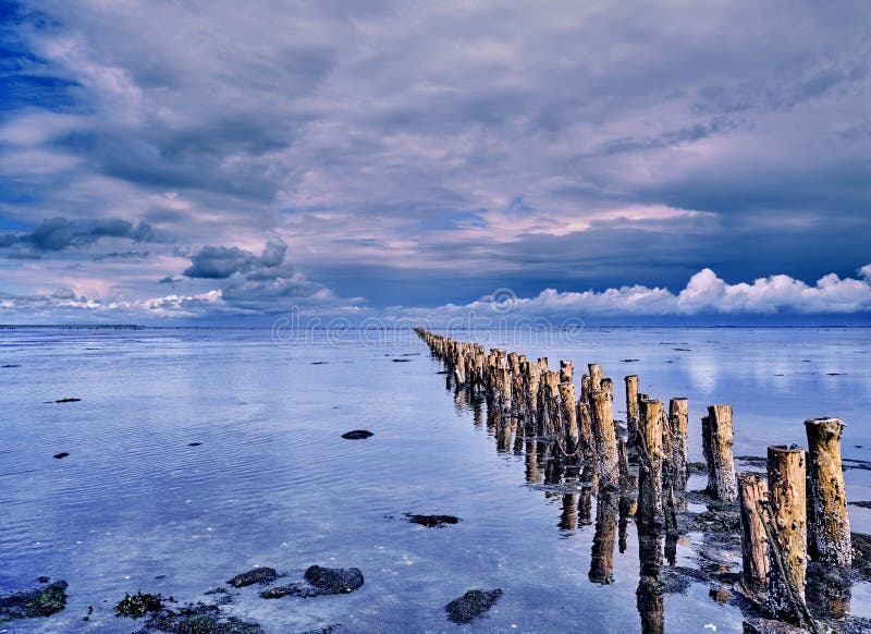 Poles In The Water - On Sunset Clouds And Ocean Stock Photo - Image of ...