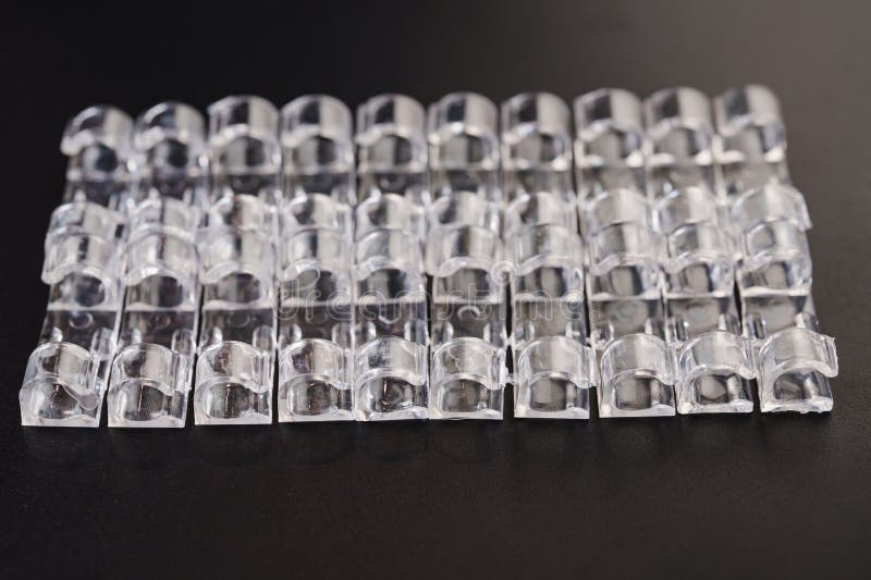 Lots of Clear Plastic Wire Holders on the Black Surface. Stock Image ...