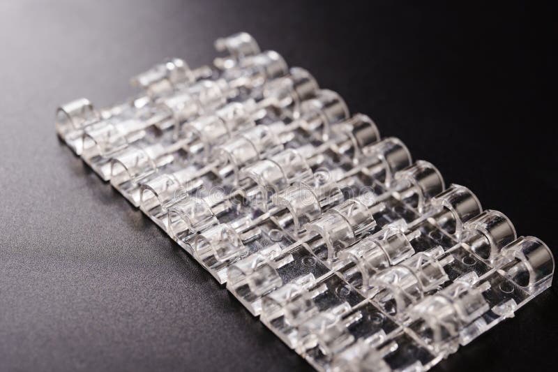 Lots of Clear Plastic Wire Holders on the Black Surface. Stock Photo ...