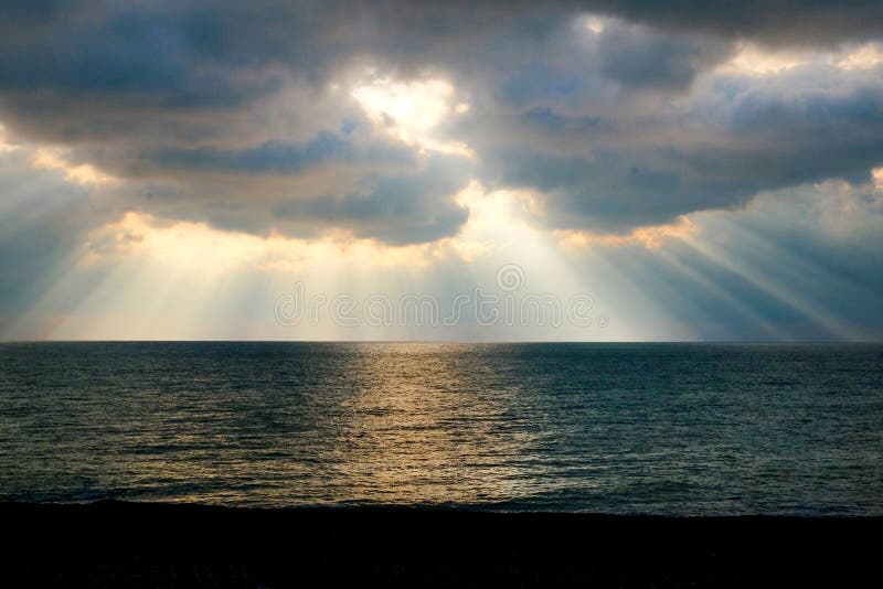 Beams of Sunlight Rays Shining through Dramatic Clouds Onto the Sea in ...