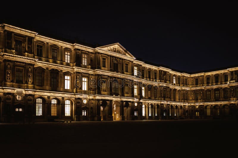Louvre Museum at Night. a Large Building with a Clock Tower and a Large ...