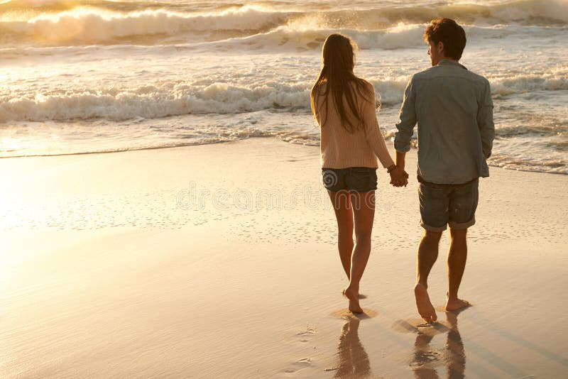 Love at the Beach. Rearview of a Young Couple Walking on the Beach at ...