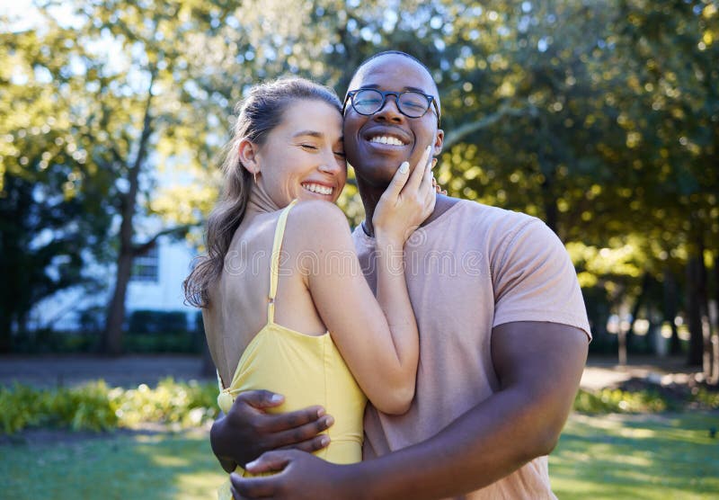 Love Interracial And Couple Hug In Park Bonding And Happiness For