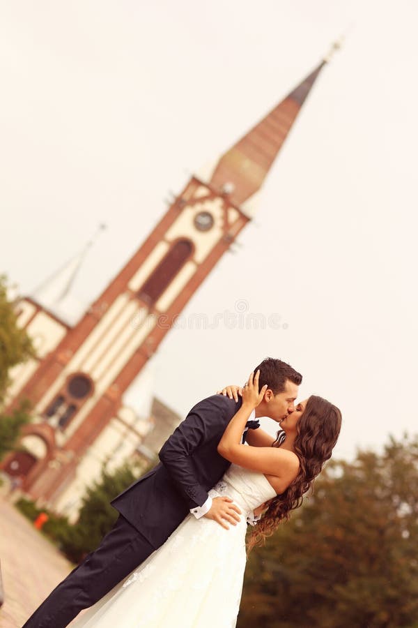 Lovely Bride and Groom in Front of Church Stock Photo - Image of hold ...