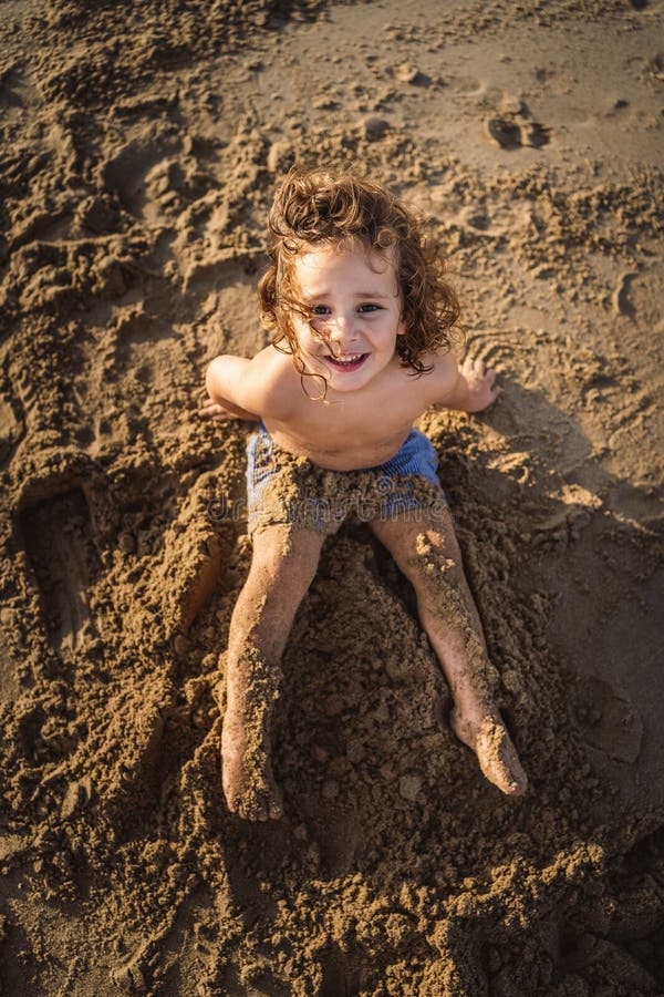 Lovely Happy Child Sitting on the Sand Looking Up Smiling Stock Image ... Lovely Happy Child Sitting on the Sand Looking Up Smiling Stock Image ...