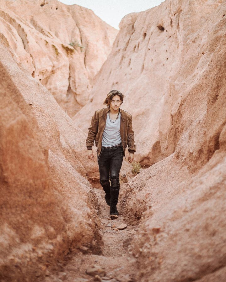A Lovely Young Boy Walking between Walls of Sand Stock Photo - Image of ...