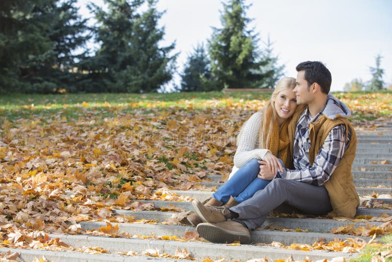 Loving Couple Hugging while Sitting on Steps in Park during Autumn ...