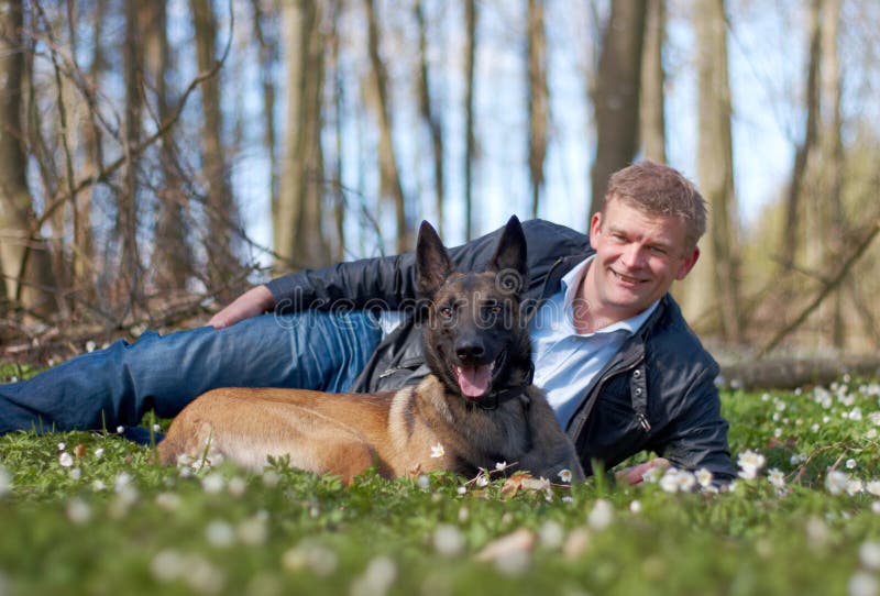 A Loving Friend. a Man and His Dog Sitting in the Forest Together ...