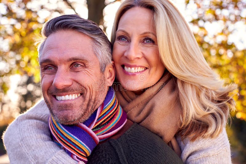 Loving Mature Woman Hugging Man From Behind As Retired Couple Walk