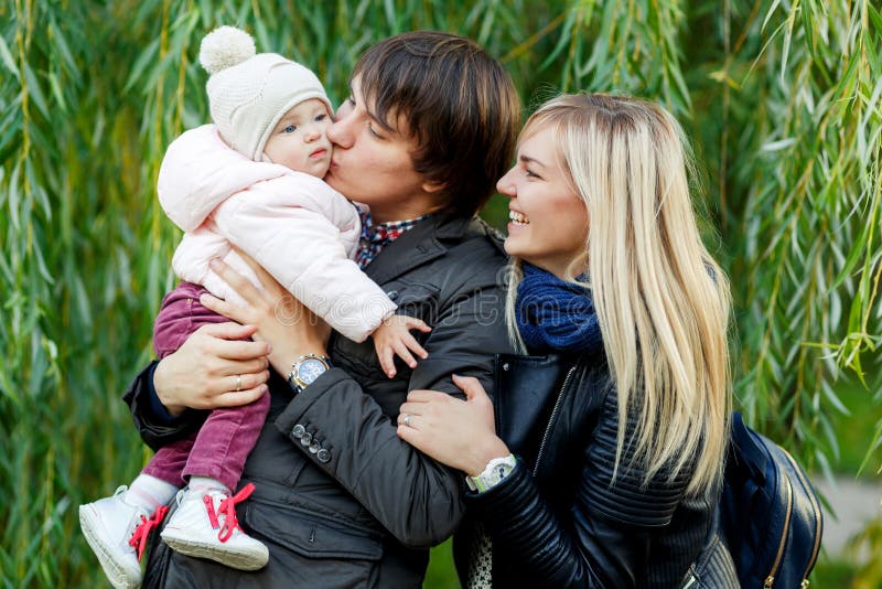 Loving Parents with Daughter in Park Stock Photo - Image of hands, male ...