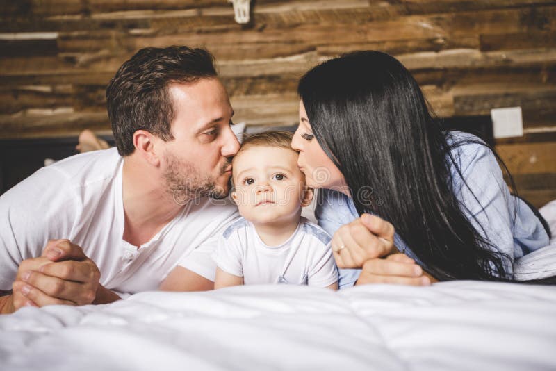 Loving Parents with Their Cute Little Boy on Bed Stock Photo - Image of ...