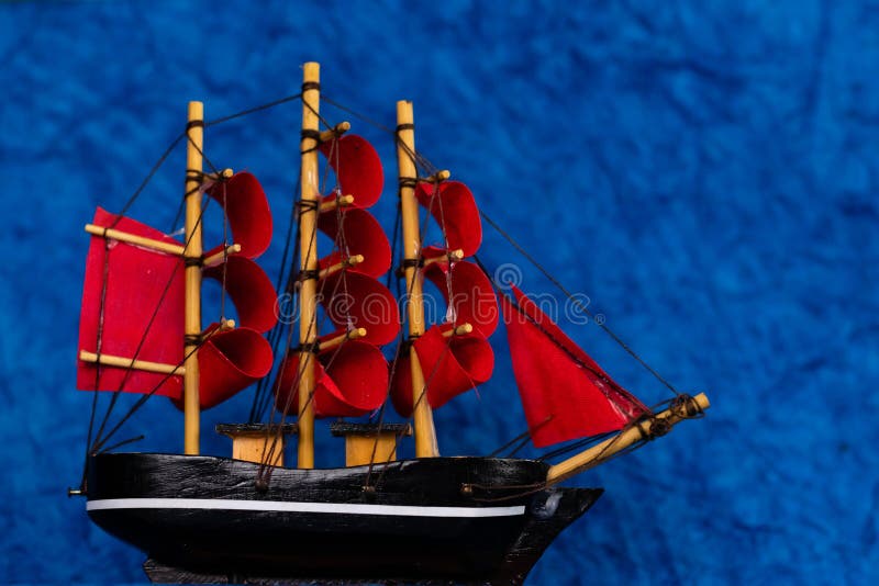 Low Angle Close Up Shot of a Toy Boat with Red Sails and Blue Background Stock Photo - Image of ...