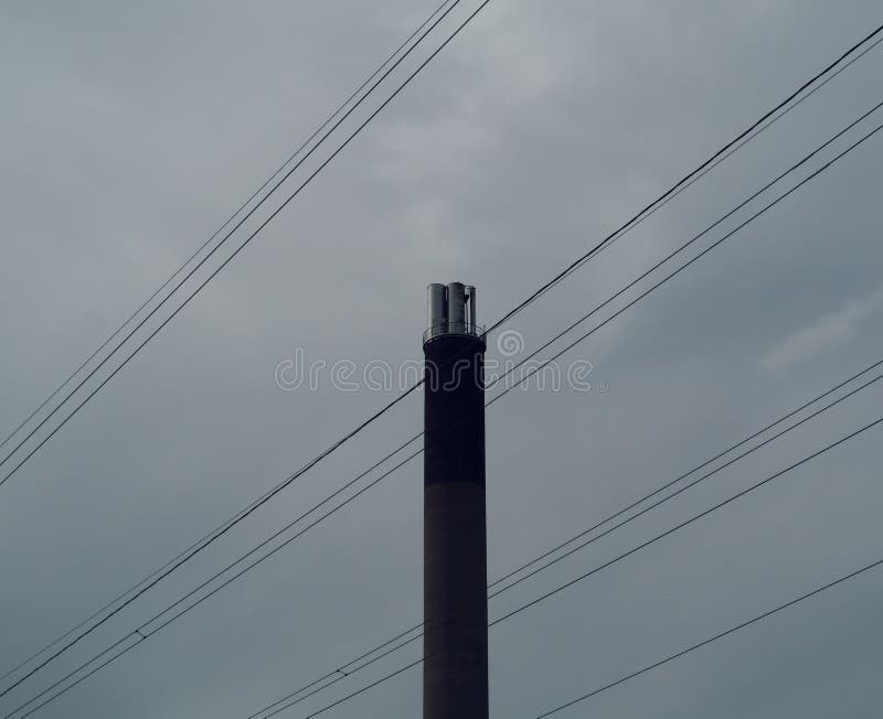 Low Angle of Electric Cables in Front of Industrial Chimney Stock Photo ...