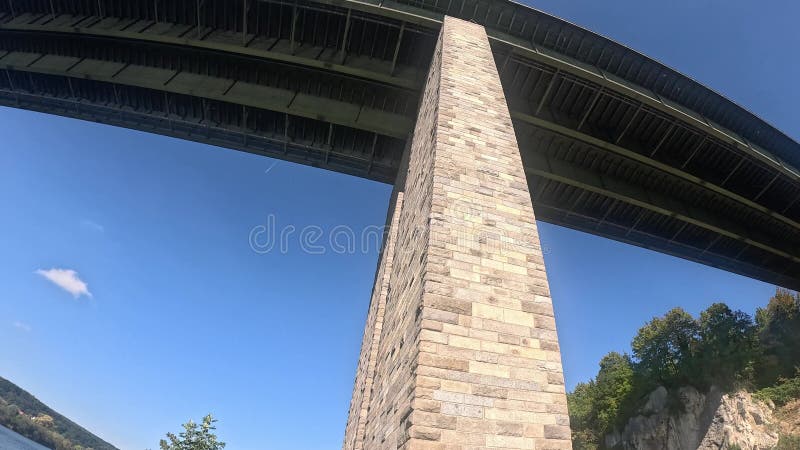 Low Angle Footage of a Bridge Crossing a River Flowing in the Woods ...