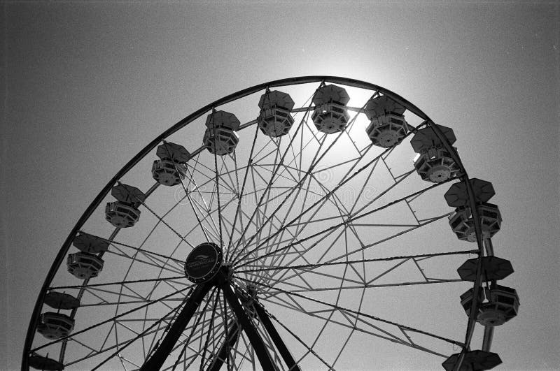 Low Angle Grayscale of a Ferris Wheel with the Sun Shining Behind it ...
