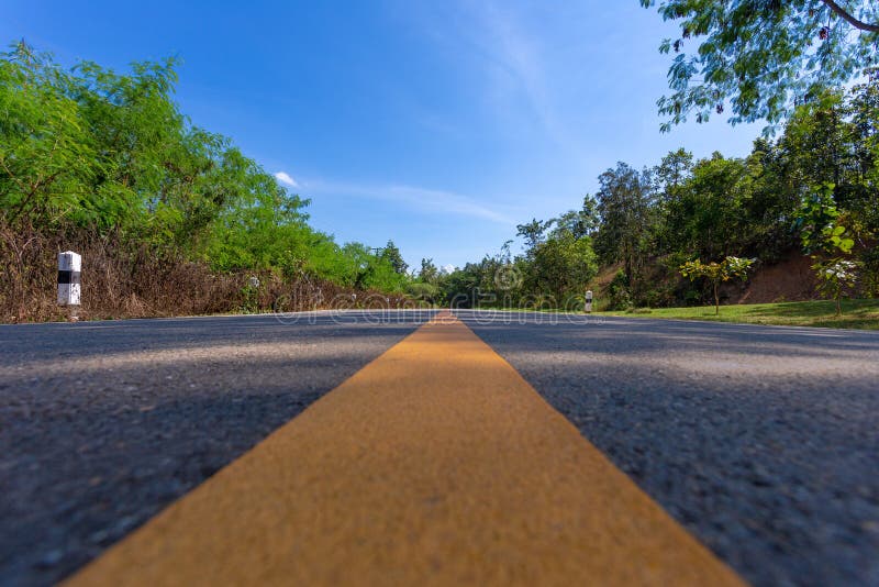 Low Angle of Middle of Straight Road with Bushes and Trees on Bo Stock ...