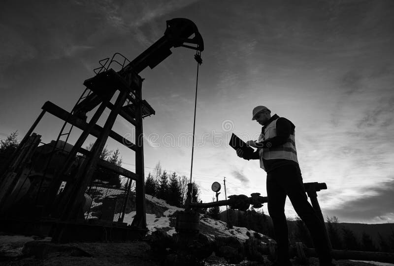 Petroleum Operator Pointing at Oil Well Pump Jack. Stock Photo - Image ...