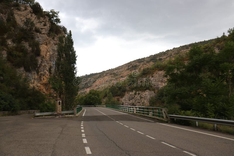 Low-angle of a Road through Rocky Mountains, Gloomy Sky Background ...