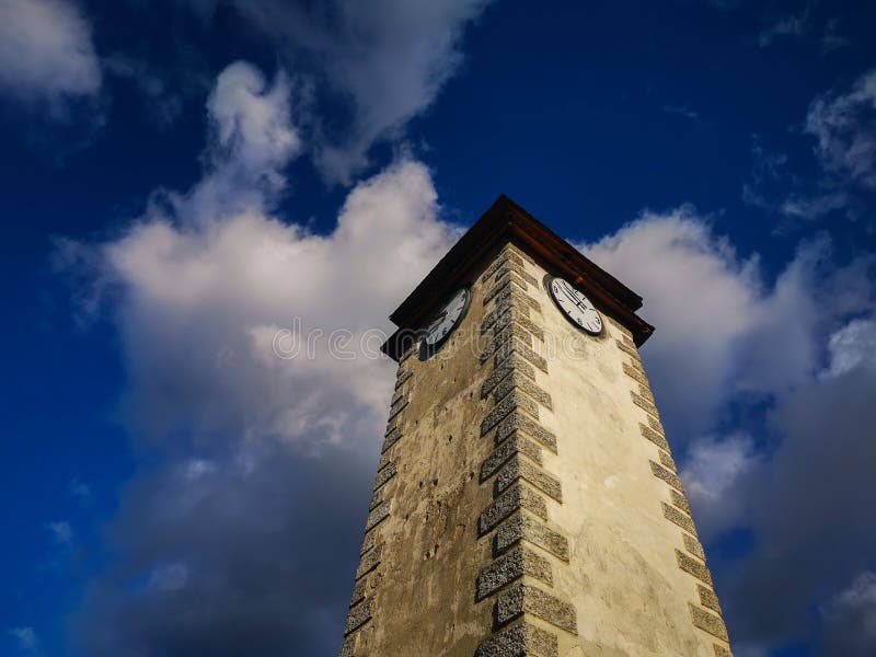 Low Angle Shot of an Aged Stone Clock Tower Against the Blue Cloudy Sky ...