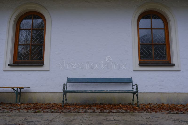 Low Angle Shot of a Bench Against a White Wall of a Building Stock ...