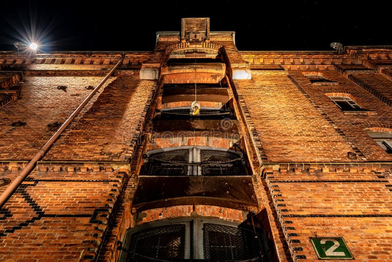 Low Angle Shot of a Brick Building with a Metal Hook Hanging from the ...