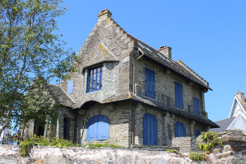 Low Angle Shot of a Brick House with Blue Window Frames and a Clear Sky ...