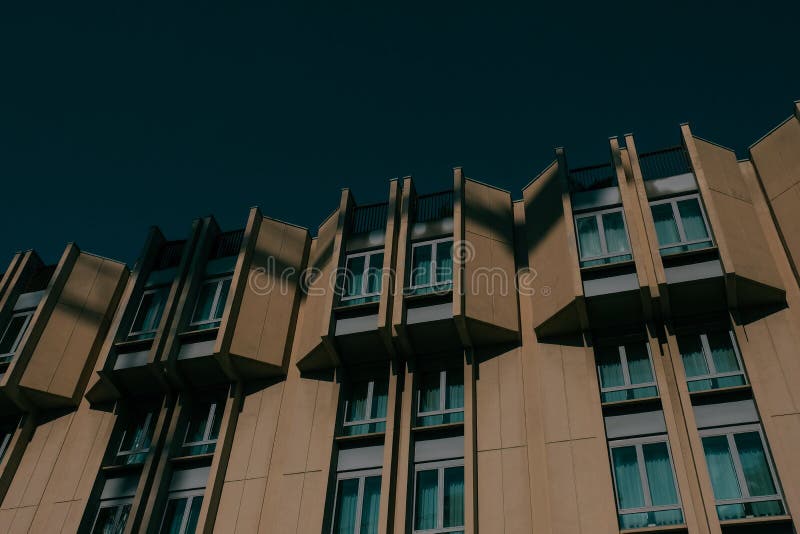 Low Angle Shot of a Brown Building with Windows and a Dark Blue Sky in ...
