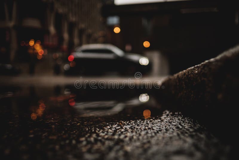 A Low Angle Shot of a Car with Reflection in the Puddle of Water Stock ...