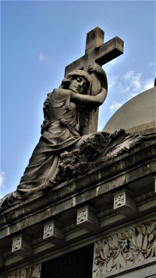 Low Angle Shot of a Female Statue Hugging the Cross on Top of a ...