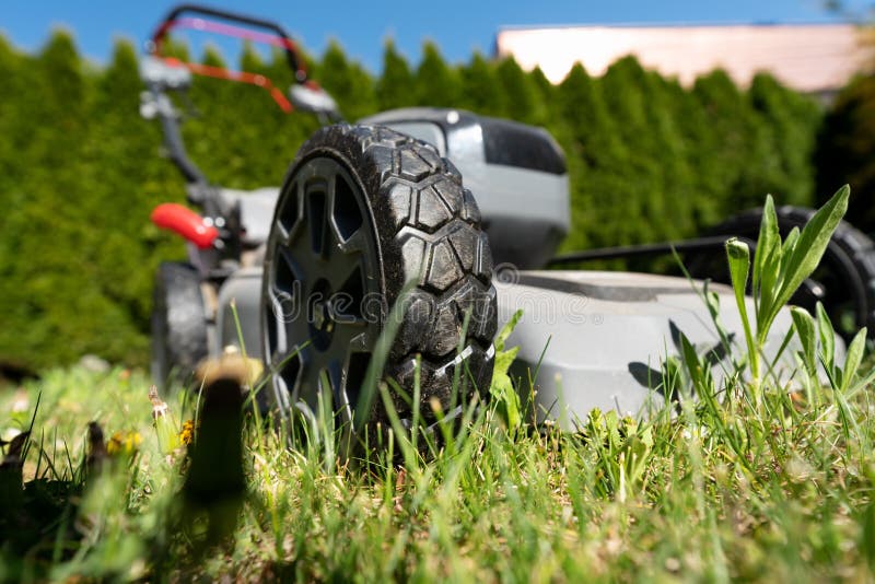 Low Angle Shot of High Grass with Mowing Machine with Focus on Wheel on ...