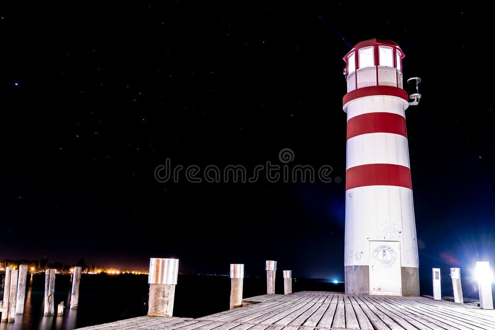 Low Angle Shot of a Lighthouse on a Dock by the Sea at Night Stock ...