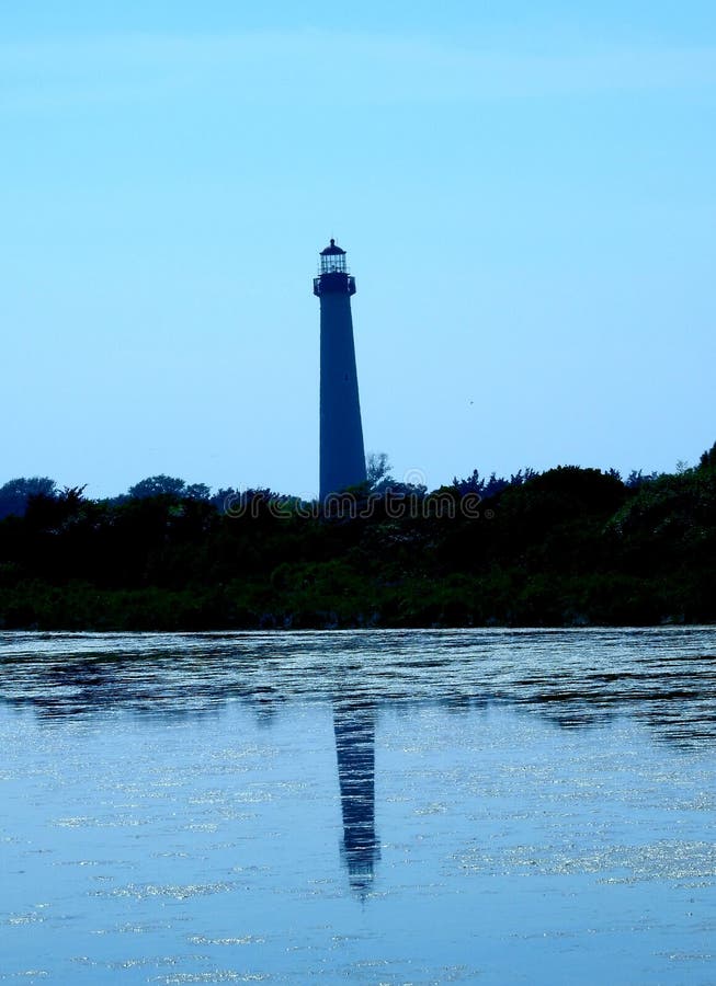 Low Angle Shot of a Lighthouse Reflected in the Water Surrounded by ...