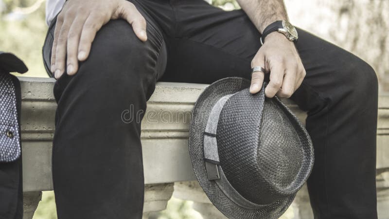 Low Angle Shot of a Male Holding a Fedora Hat while Sitting on the ...