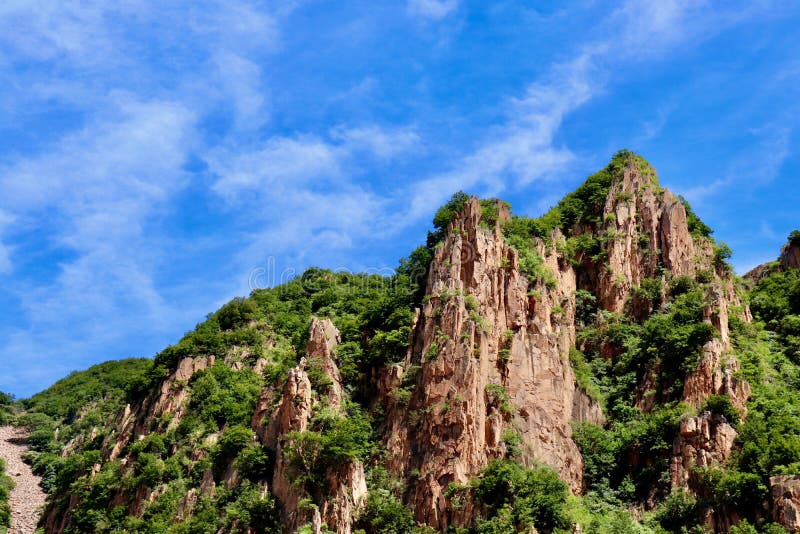 Low Angle Shot of Massive Outcrops Covered with Greenery on a Mountain ...