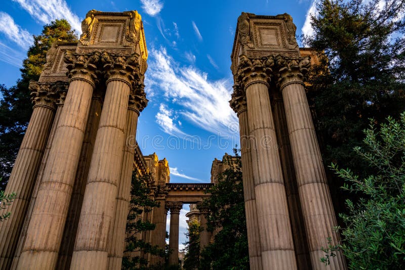 Low Angle Shot of an Old Pillars Surrounded by Trees Under Blue Cloudy ...