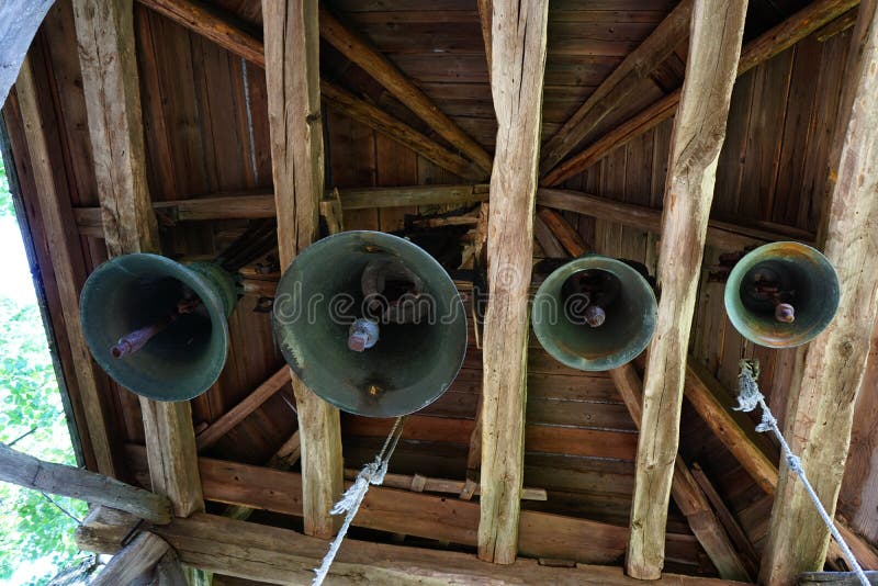 Low Angle Shot of Old Rusty Bells Hanging from a Wooden Ceiling at ...