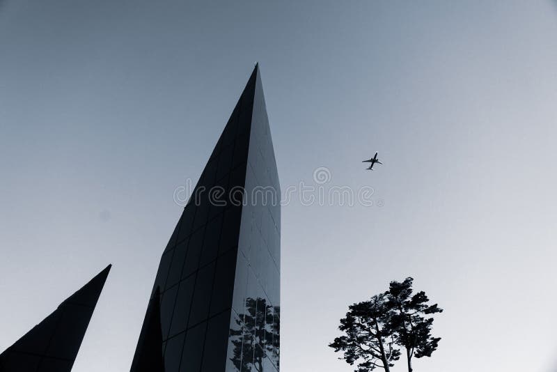 Low Angle Shot of a Plane Flying Above Modern Glass Skyscrapers Stock ...