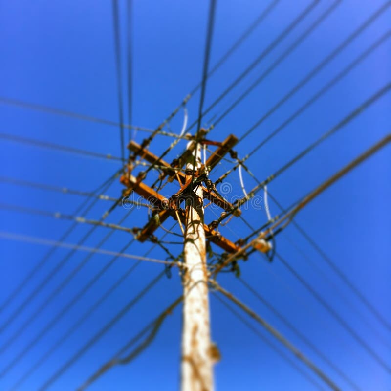 Low Angle Shot of a Pole with Electricity Wires Under a Clear Blue Sky ...