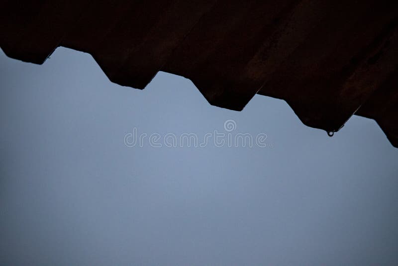 Low Angle Shot of Raindrops Falling from a Roof in the Early Morning ...