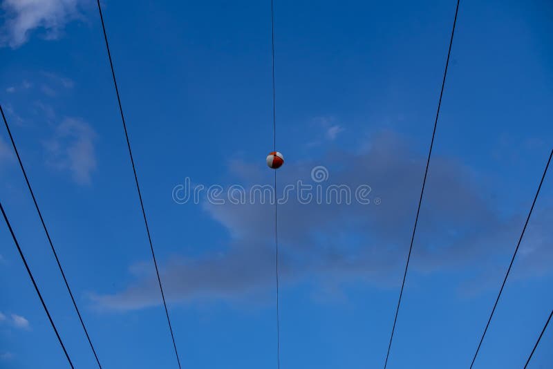 Low Angle Shot of a Red and White Ball Hangs from a High-voltage Power ...