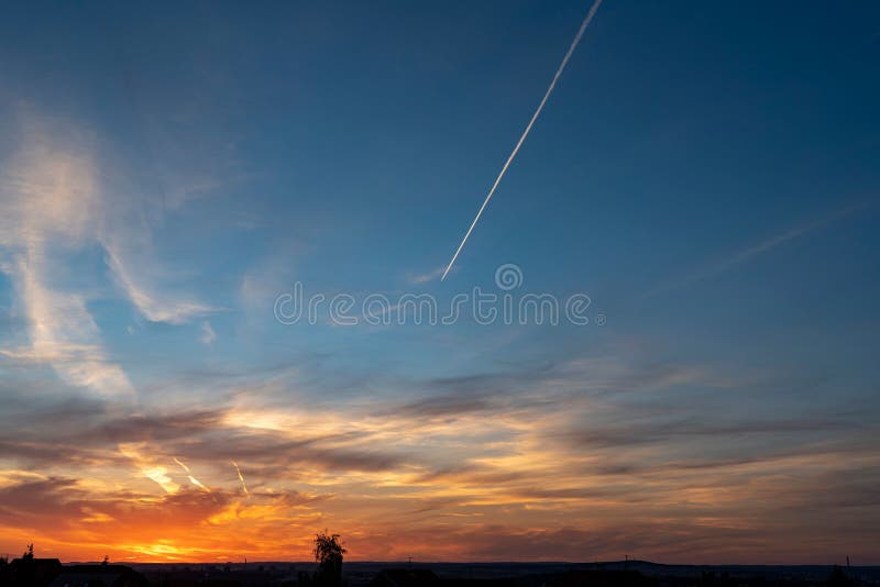 Low Angle Shot of a Sunset Sky with an Airplane Trail Stock Photo ...