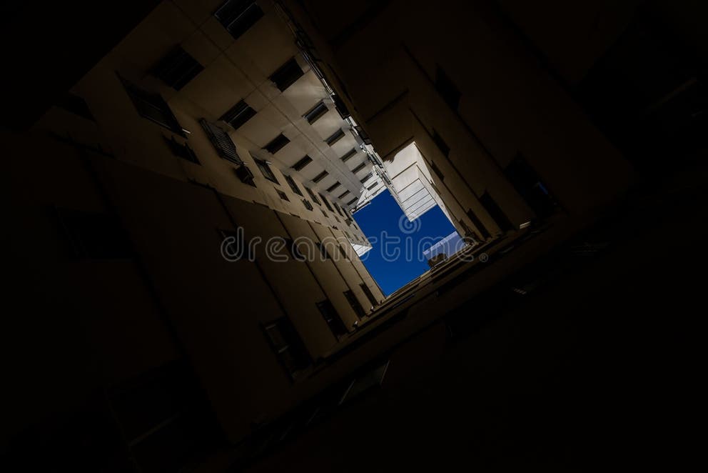 Low Angle Shot of Tall Building in Shadow with Blue Sky Above Stock ...