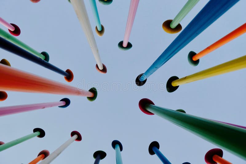 Low Angle Shot of Tall Colorful Poles in a Bright Blue Sky Stock Photo ...