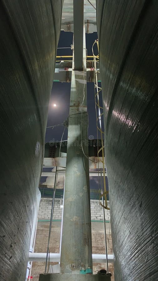 Low-angle Shot between Two Large Tanks at Night, Showing a Pillar ...